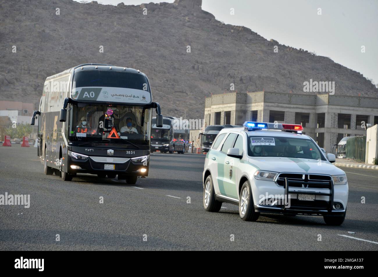 A police vehicle escorts a pilgrim convoy as they move towards the ...