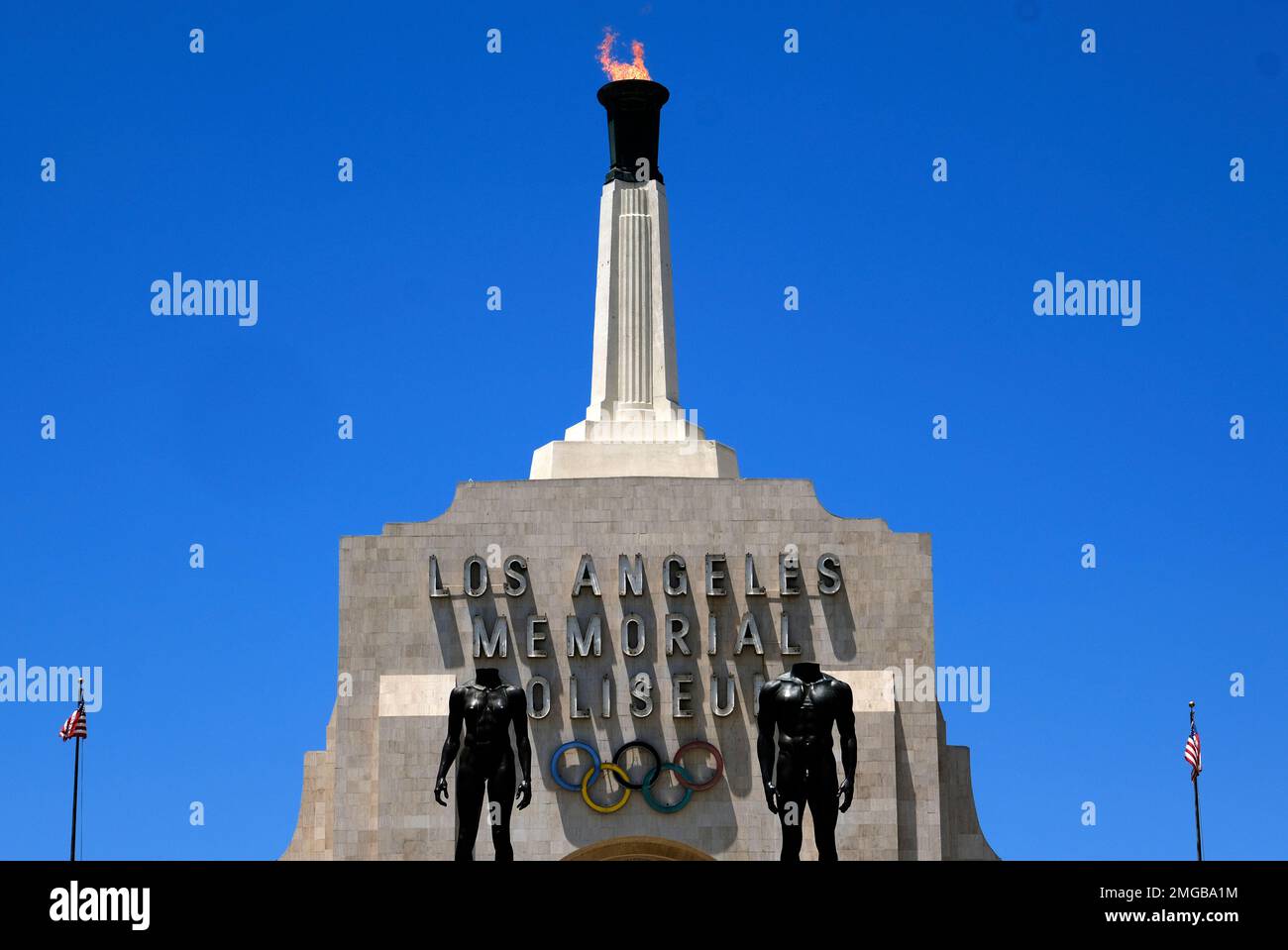 The Olympic torch is seen lit in front of the Los Angeles Memorial ...