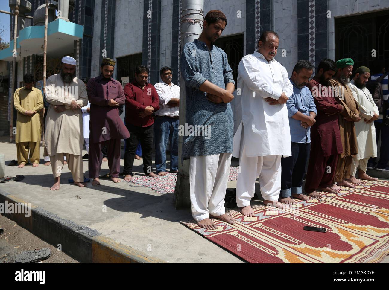Unmasked worshippers offer Friday prayers outside a mosque during a ...