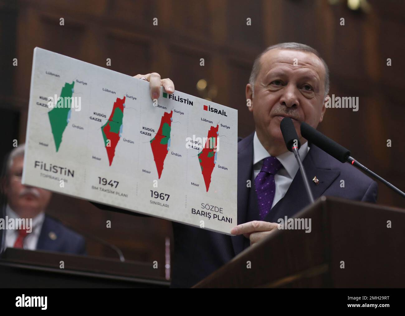 Turkey's President Recep Tayyip Erdogan holds up a placard with what he ...