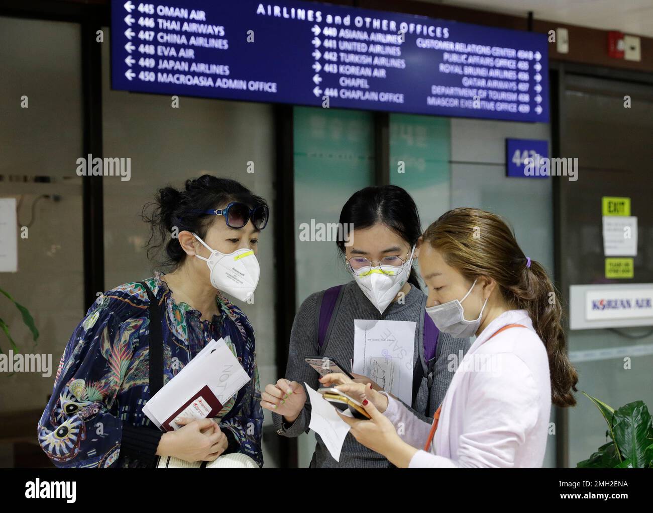 Passengers stand outside airline offices as they check their flights at the international ...
