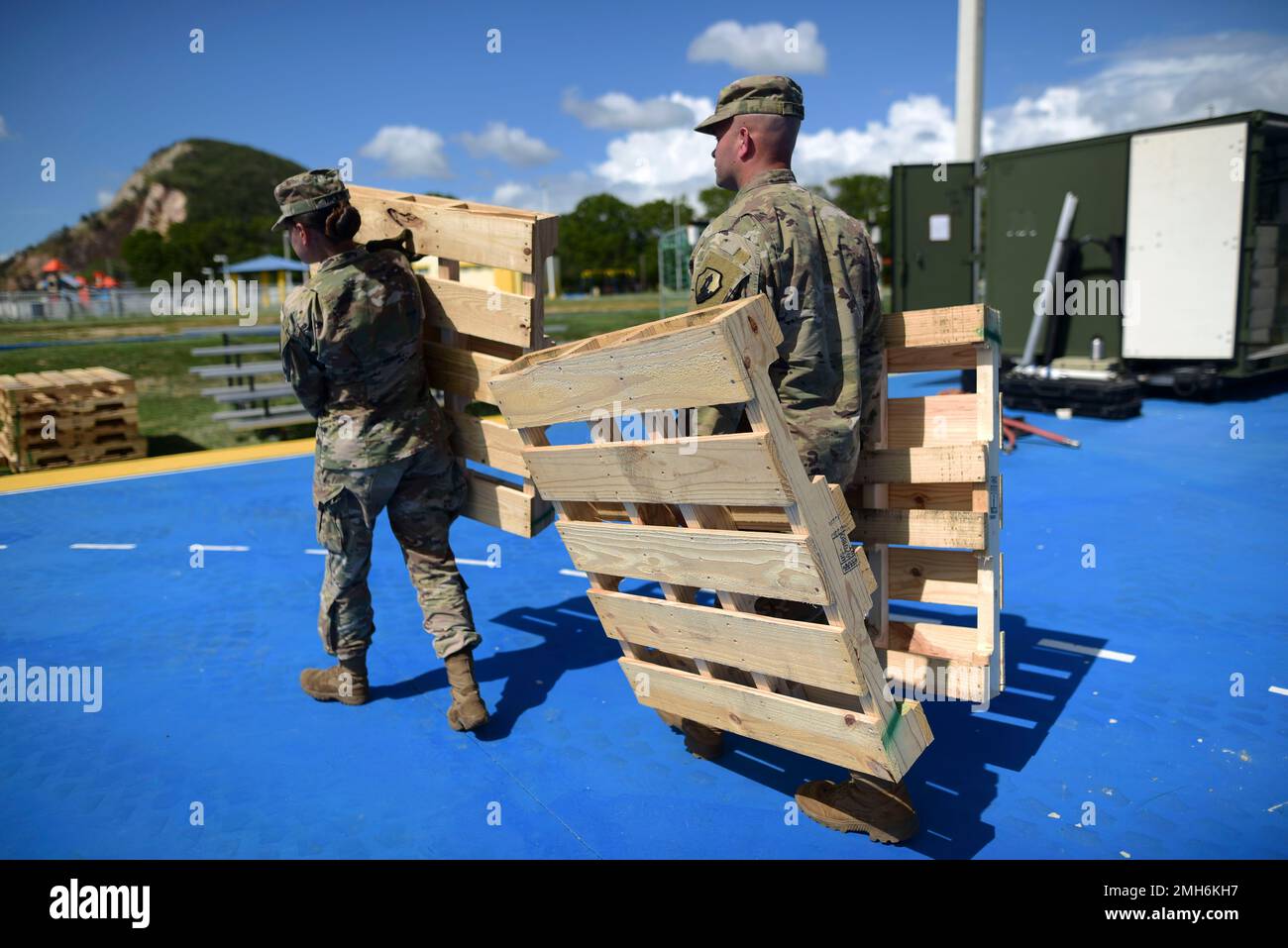 Members of the US army reserve set up portable showers in a tent city ...
