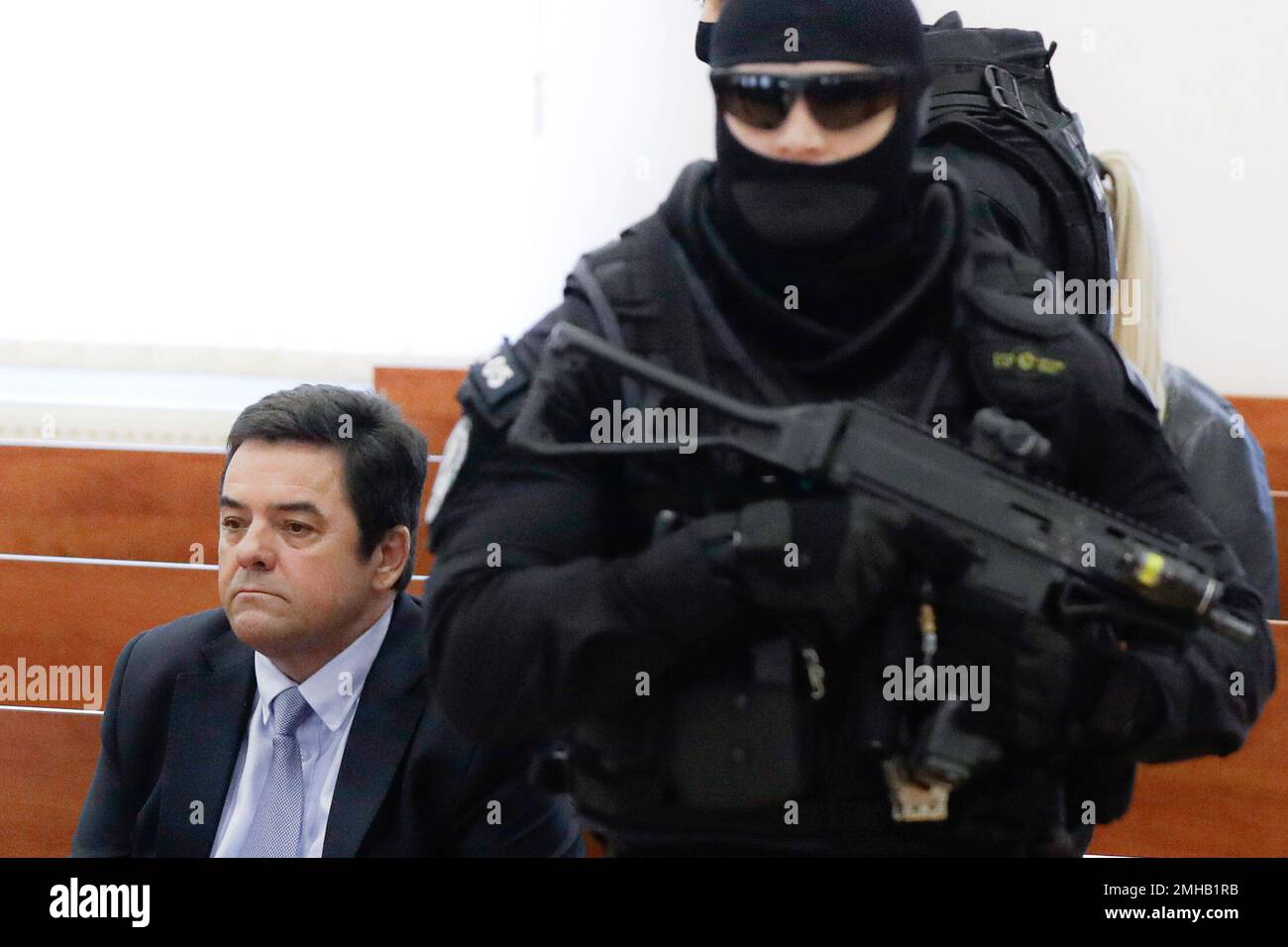 Marian Kocner sits surrounded by armed police officers in a courtroom ...