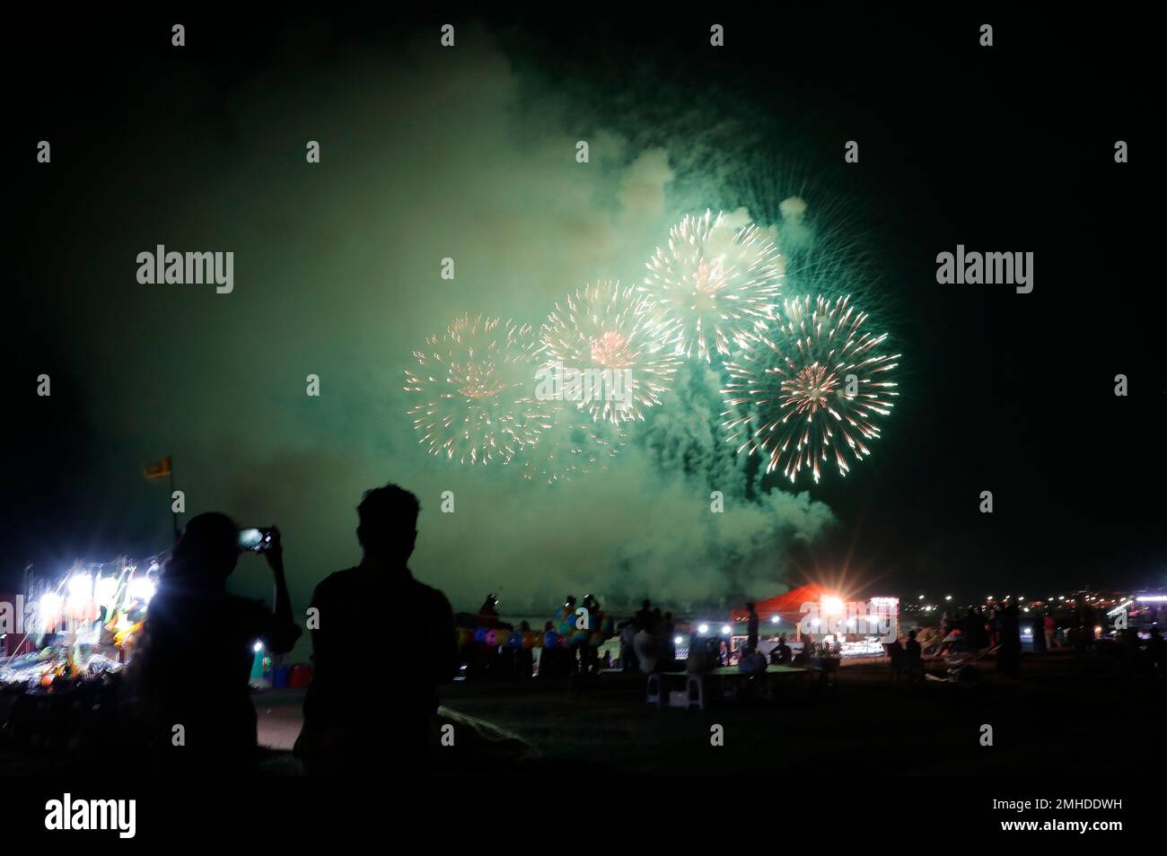 People watch as pyrotechnics go off from the reclaimed land from the ...