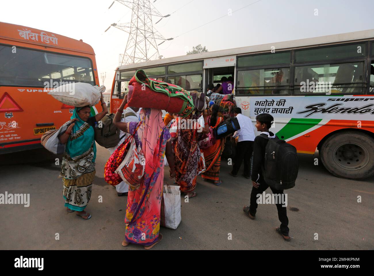 Hindu pilgrims wait in a queue to board a bus as authorities turned ...
