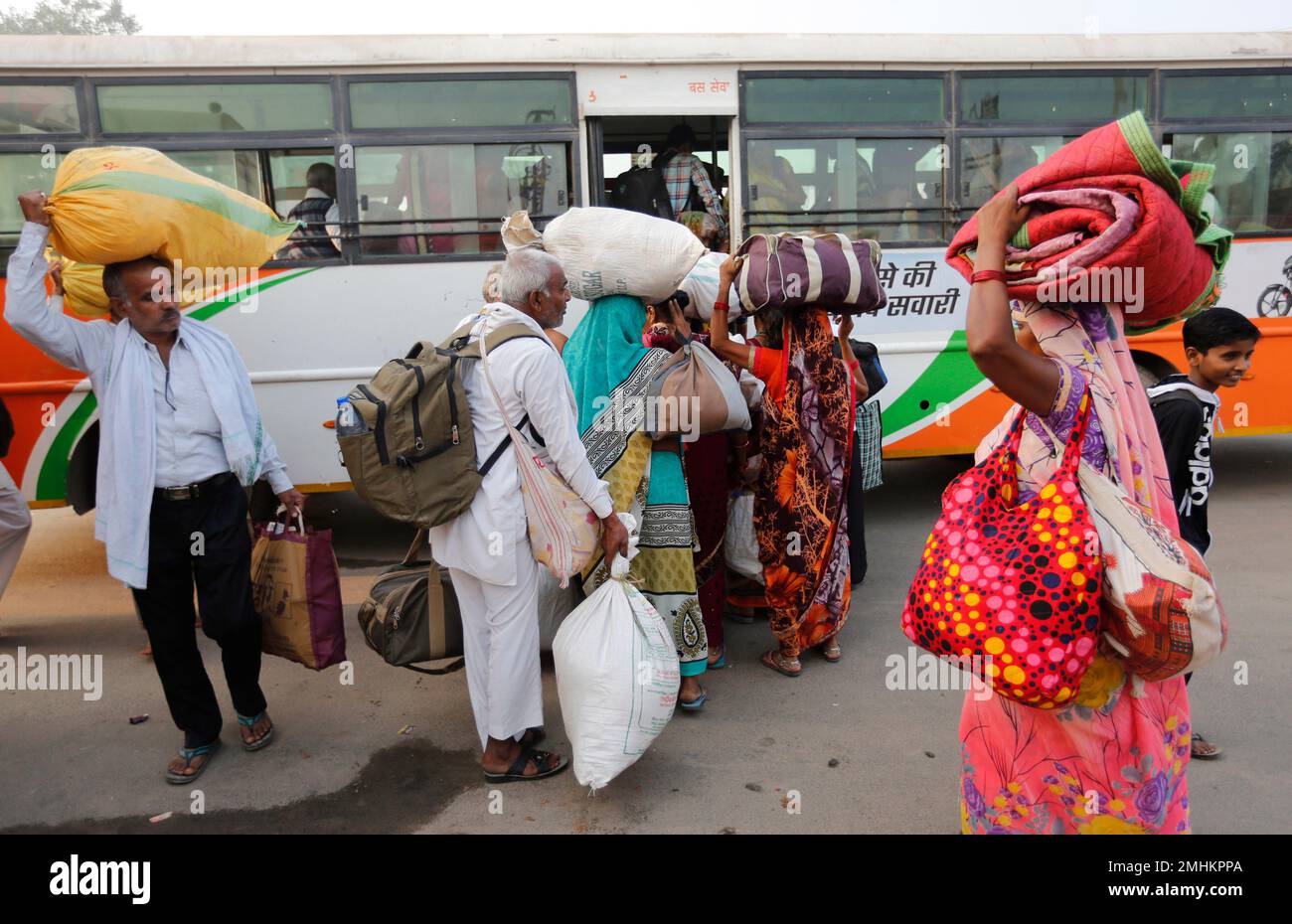 Hindu pilgrims wait in a queue to board a bus as authorities turned ...