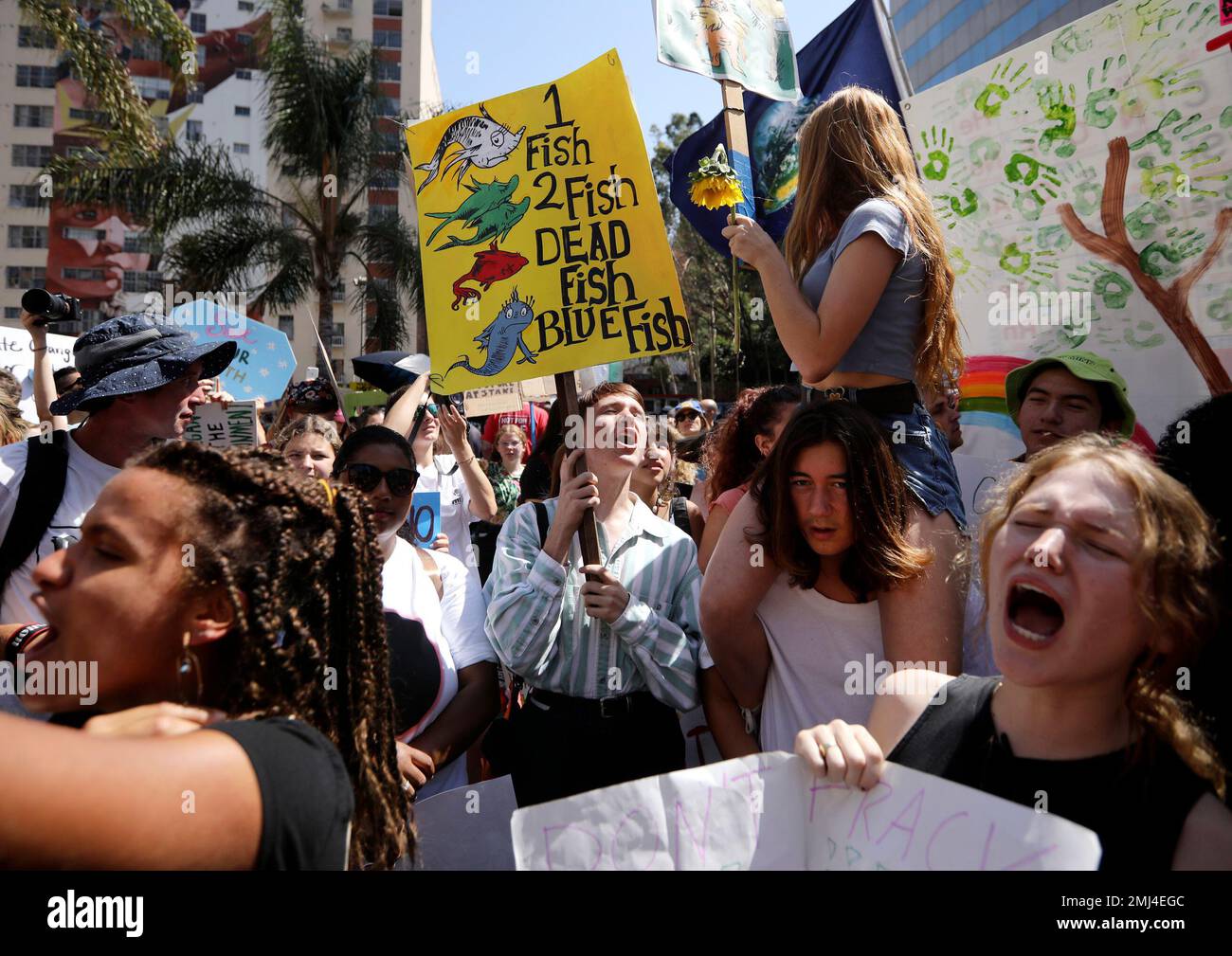 A group of young protestors chant slogans and carry signs during a ...