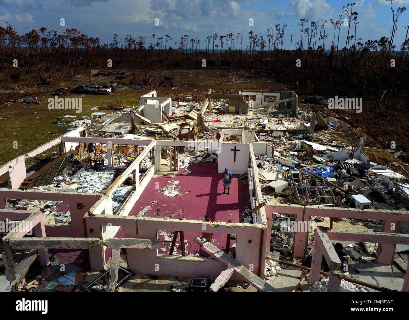 Pastor Jeremiah Saunders poses for a photo among the ruins of his ...