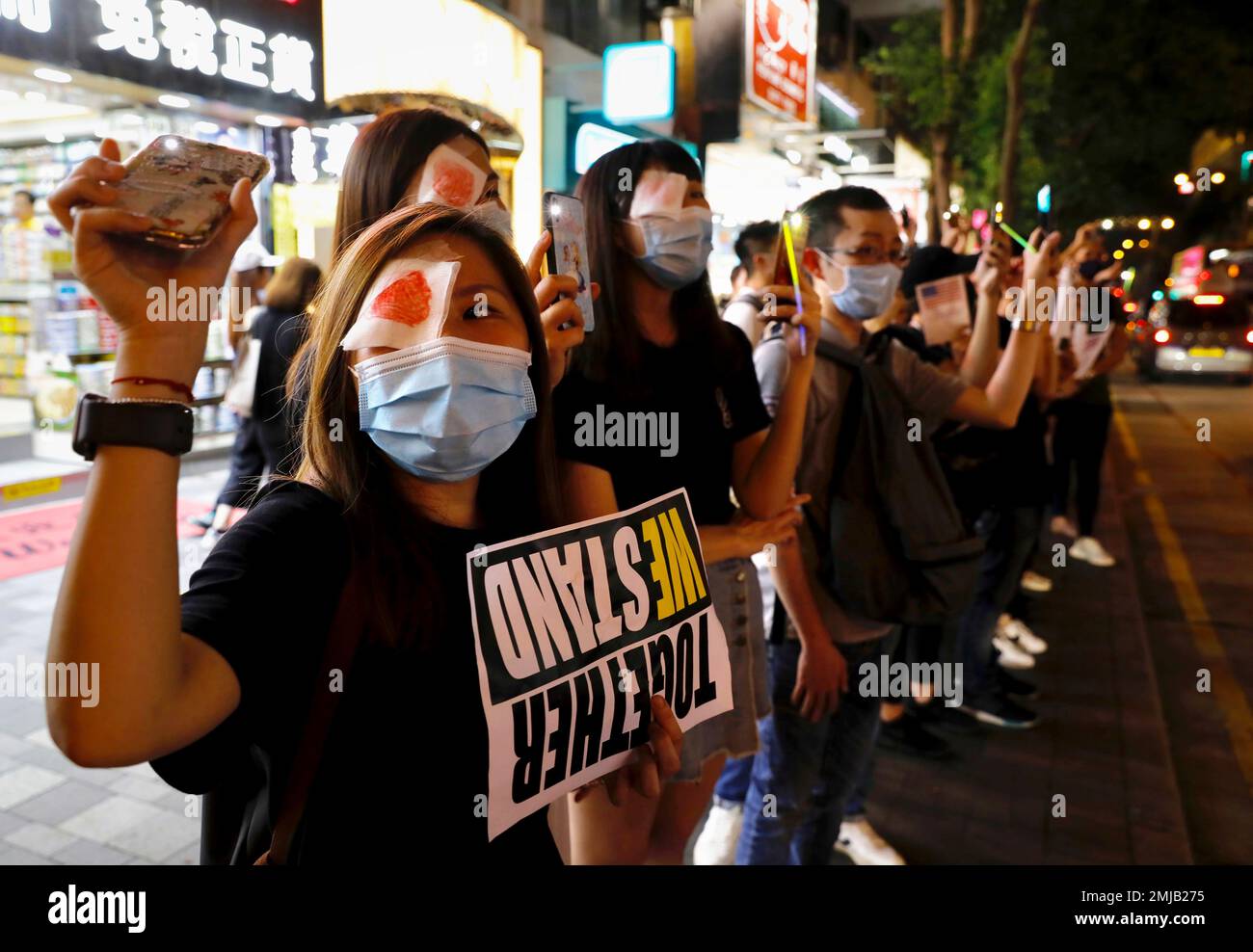 Demonstrators wear patches in remembrance of a woman who suffered an ...