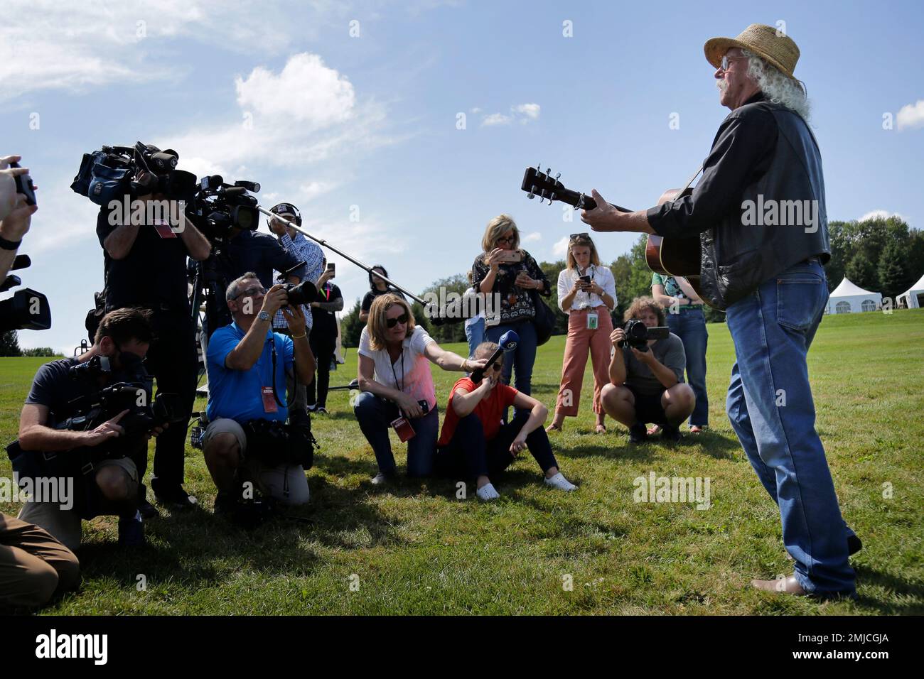 Members of the media record as Woodstock veteran Arlo Guthrie plays a ...