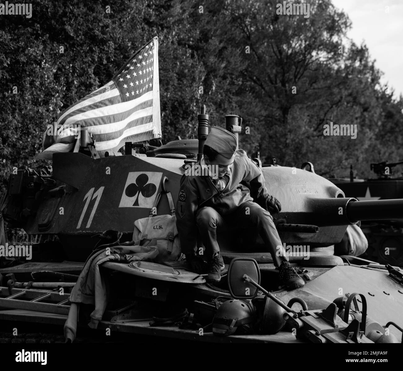 Un garçon vêtu d'une réplique d'uniforme militaire joue sur un char ...