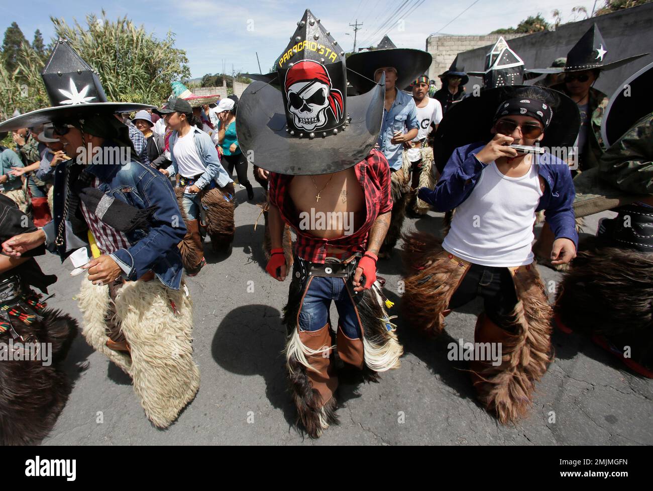 Indigenous men wearing heavy hats that also serve as shields, dance at ...