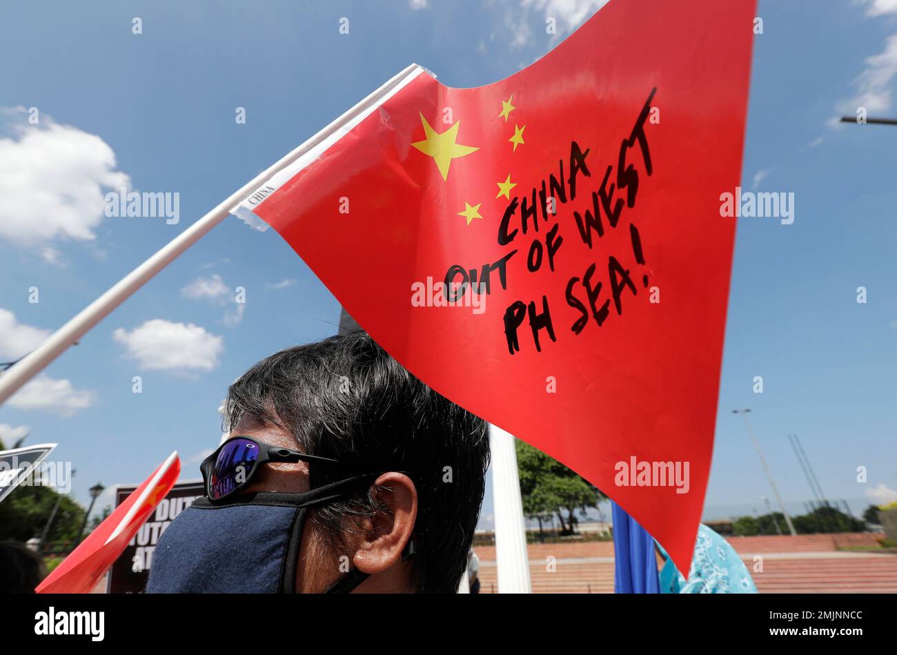 A protester holds a mock Chinese flag at Manila's Rizal park ...