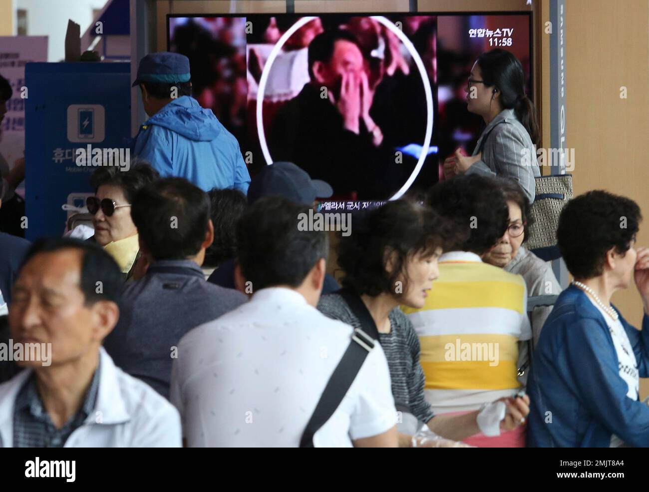 People watch a TV screen showing an image of senior North Korean ...