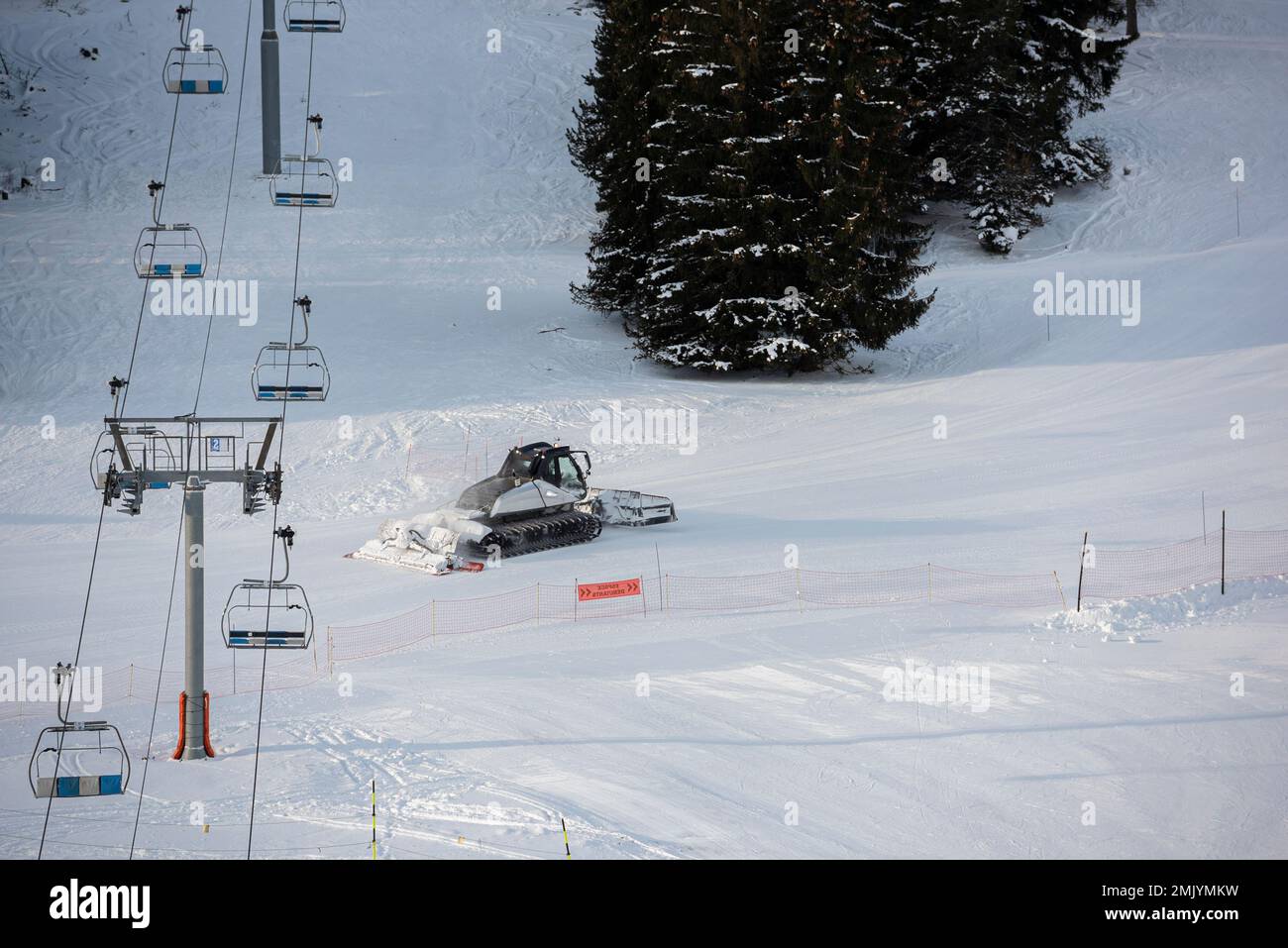 Tondeuse à neige sur une piste de ski, station de ski dans les Alpes ...