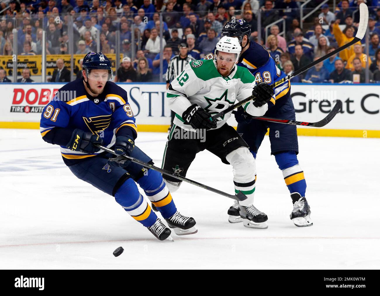 St. Louis Blues' Vladimir Tarasenko (91) and Dallas Stars' Radek Faksa (12) chase after a loose ...