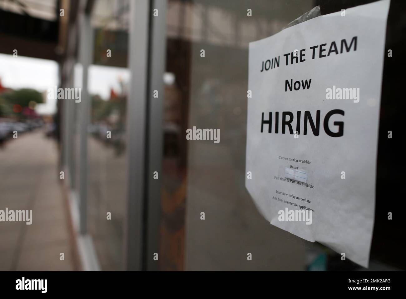 FILE - In this July 18, 2018, file photo a "now hiring" sign hangs in ...