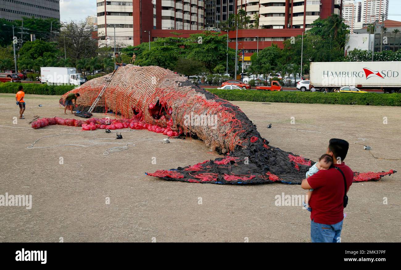 A father cuddles his baby as he watches workers put finishing touches ...