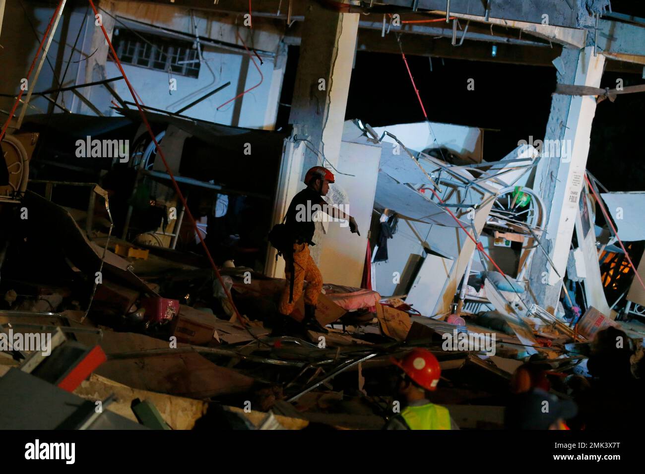 A rescuer searches for survivors following a magnitude 6.1 earthquake ...