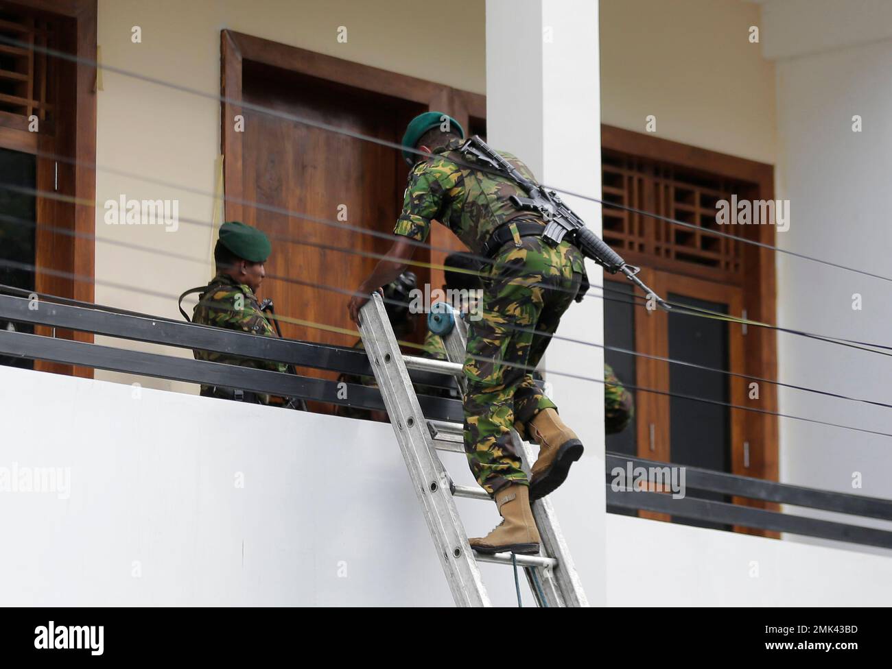 A Sri Lankan police commando enters a house suspected to be a hideout ...