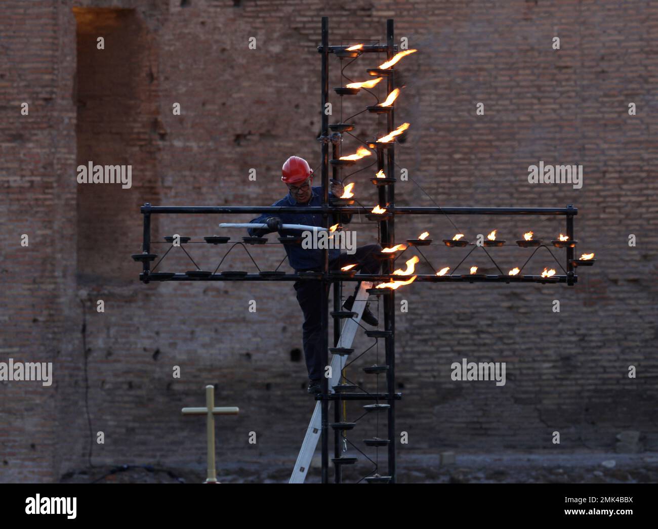 Workers light up the cross at the start of the Via Crucis (Way of the ...