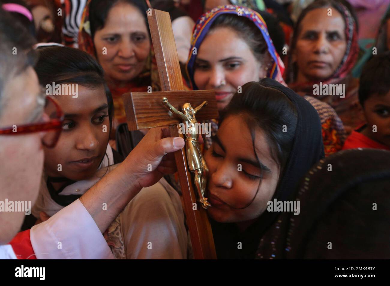 Pakistani Christians kiss a crucifix of Jesus Christ during a Good ...
