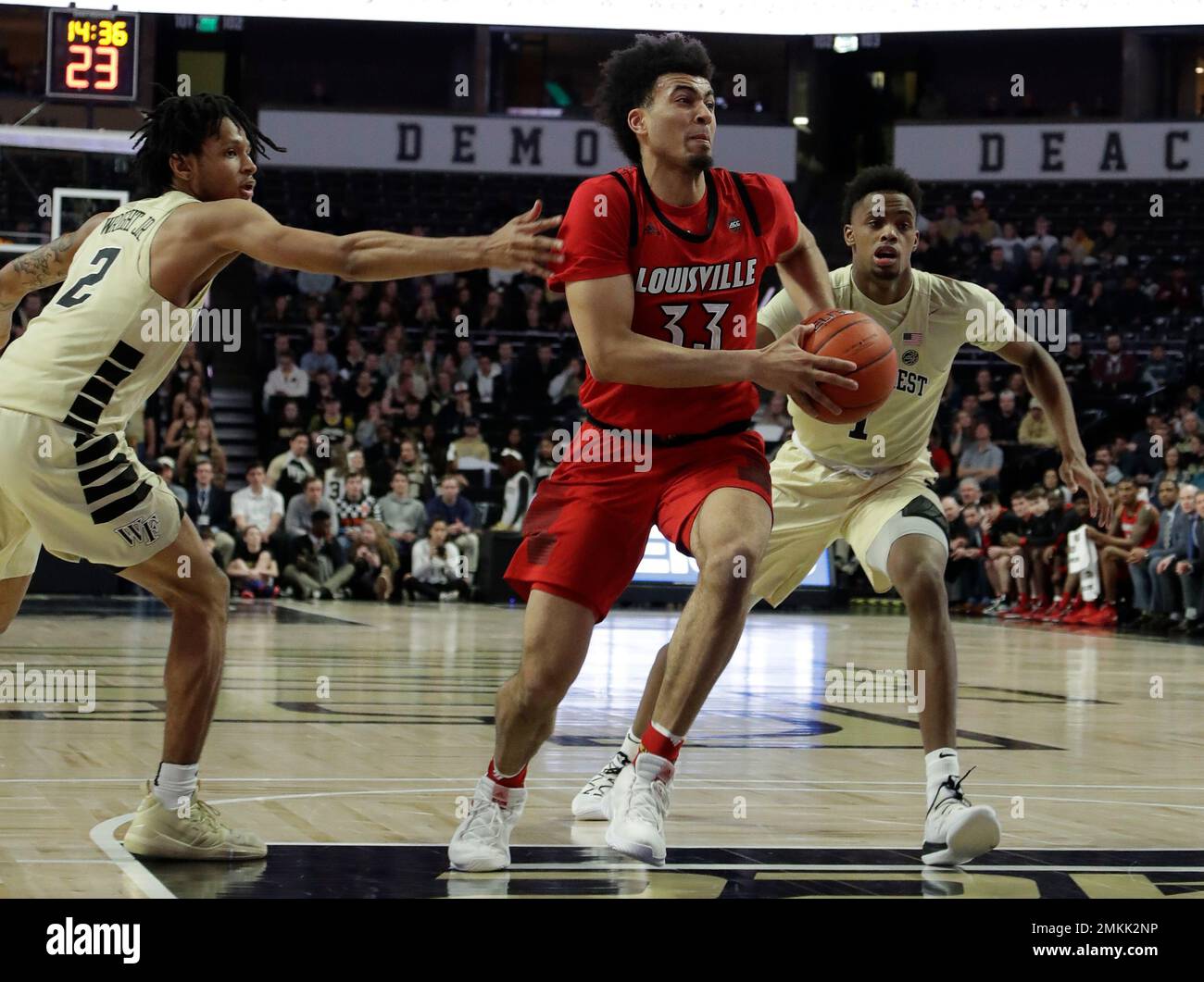 Louisville's Jordan Nwora (33) drives past Wake Forest's Sharone Wright ...