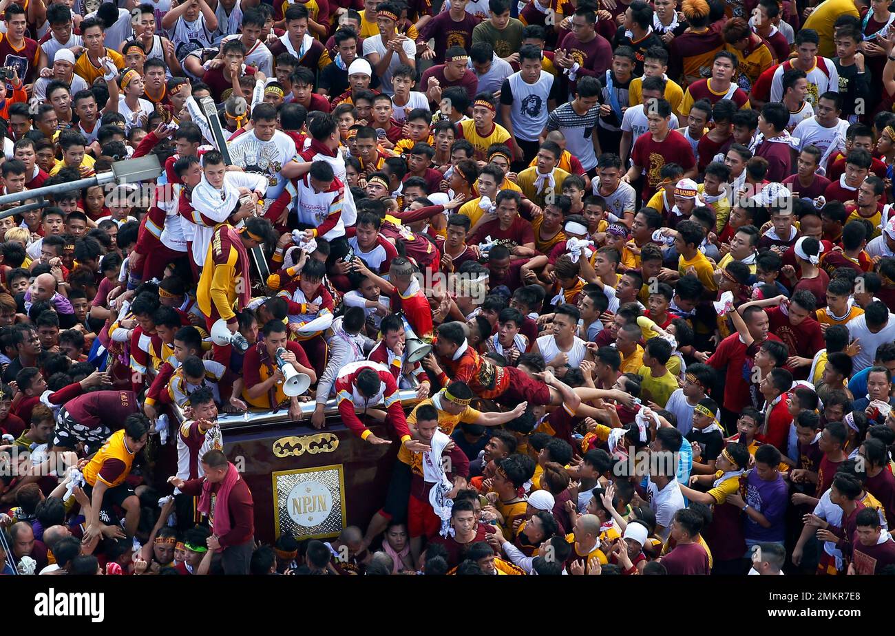 Roman Catholic devotees clamber to kiss and rub with towels the image ...
