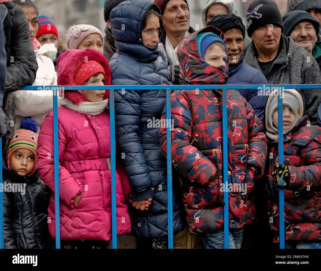 Homeless people and their children wait to receive clothing and warm ...