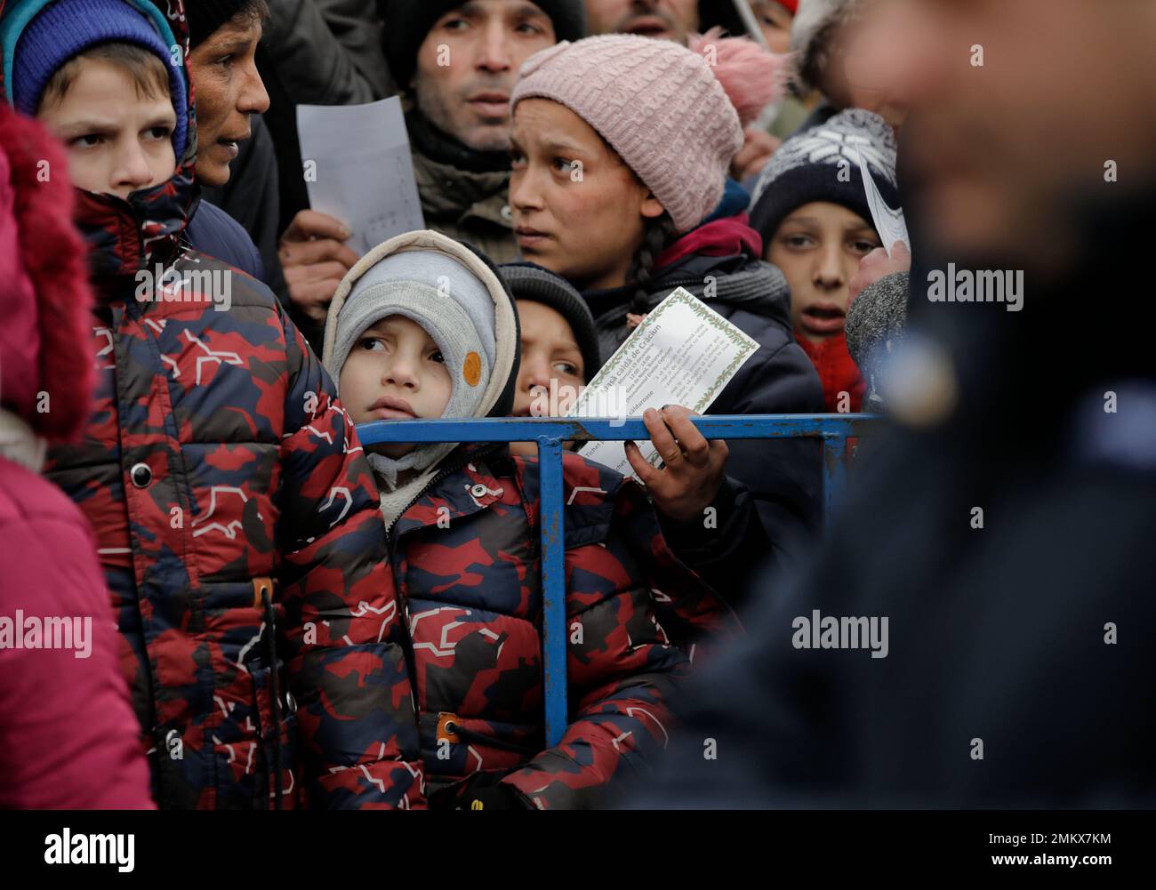 Homeless people and their children wait to receive clothing and warm ...