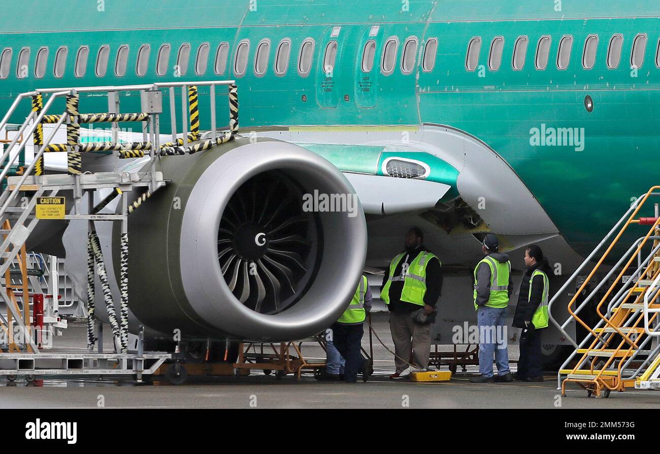 Workers stand next to a engine of a Boeing 737-MAX 8, Wednesday, Nov ...