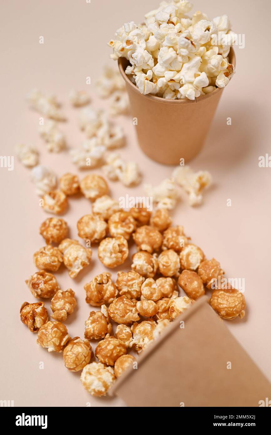 Deux types de pop-corn dans deux tasses en papier. Сaramel et pop-corn ...