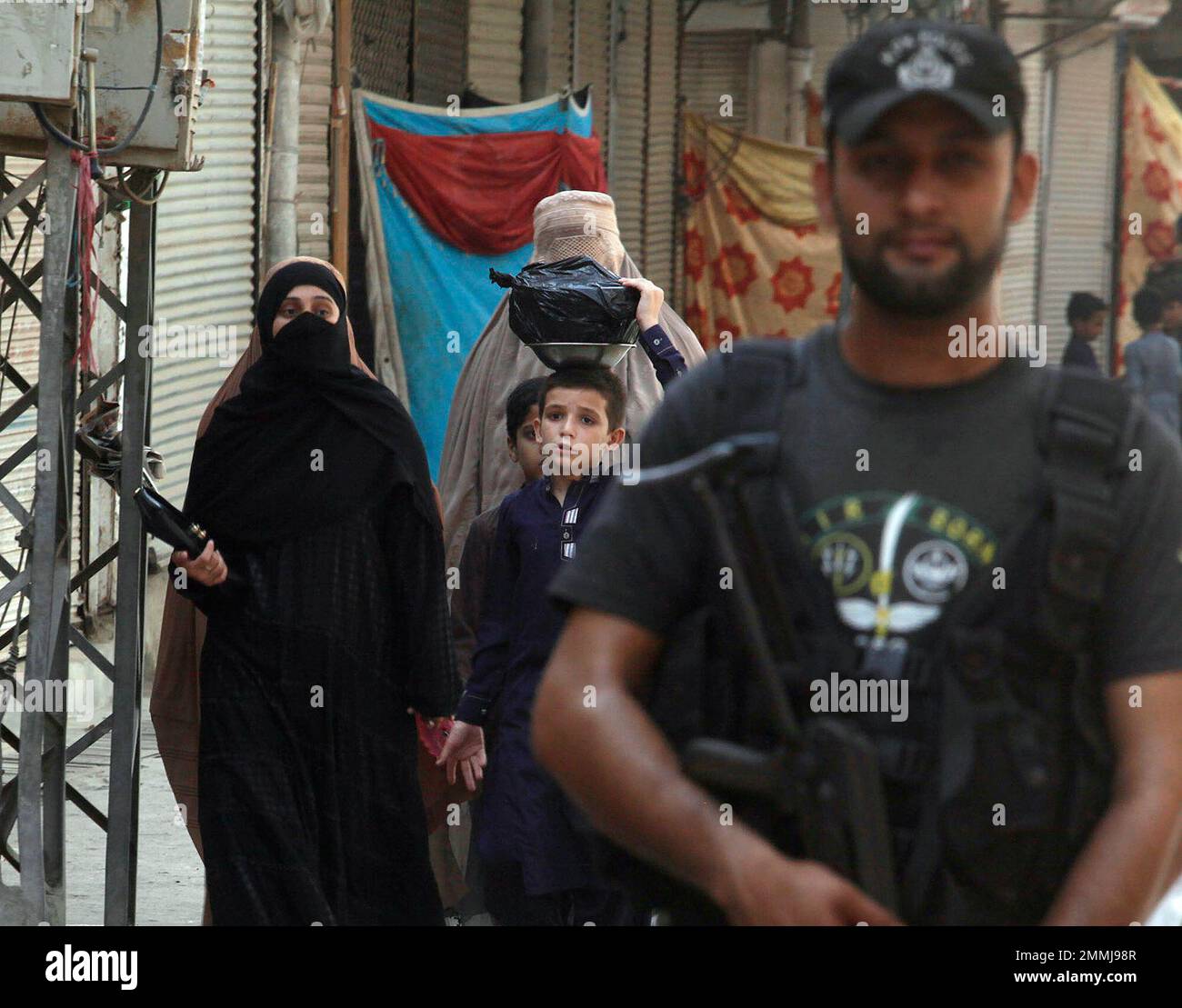 A Pakistani police commando stands guard during a Muharram procession ...