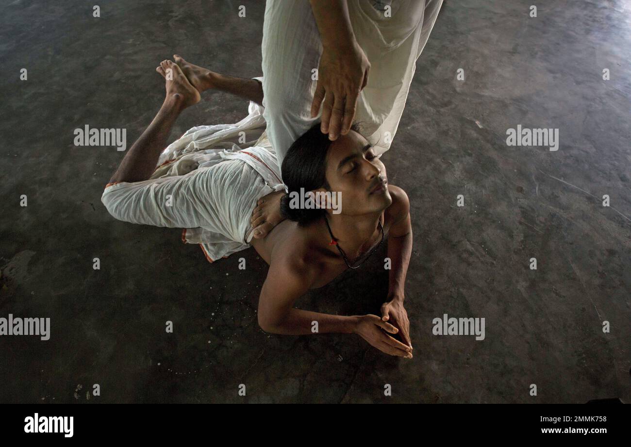 In this Tuesday, Aug. 7, 2018, photo, a guru, or teacher, helps a young ...