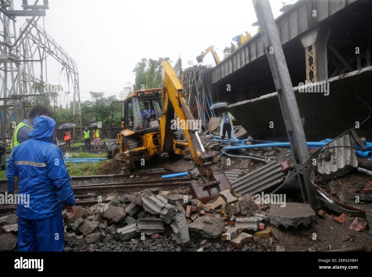 Rescuers work at the site of a pedestrian bridge that collapsed at a ...