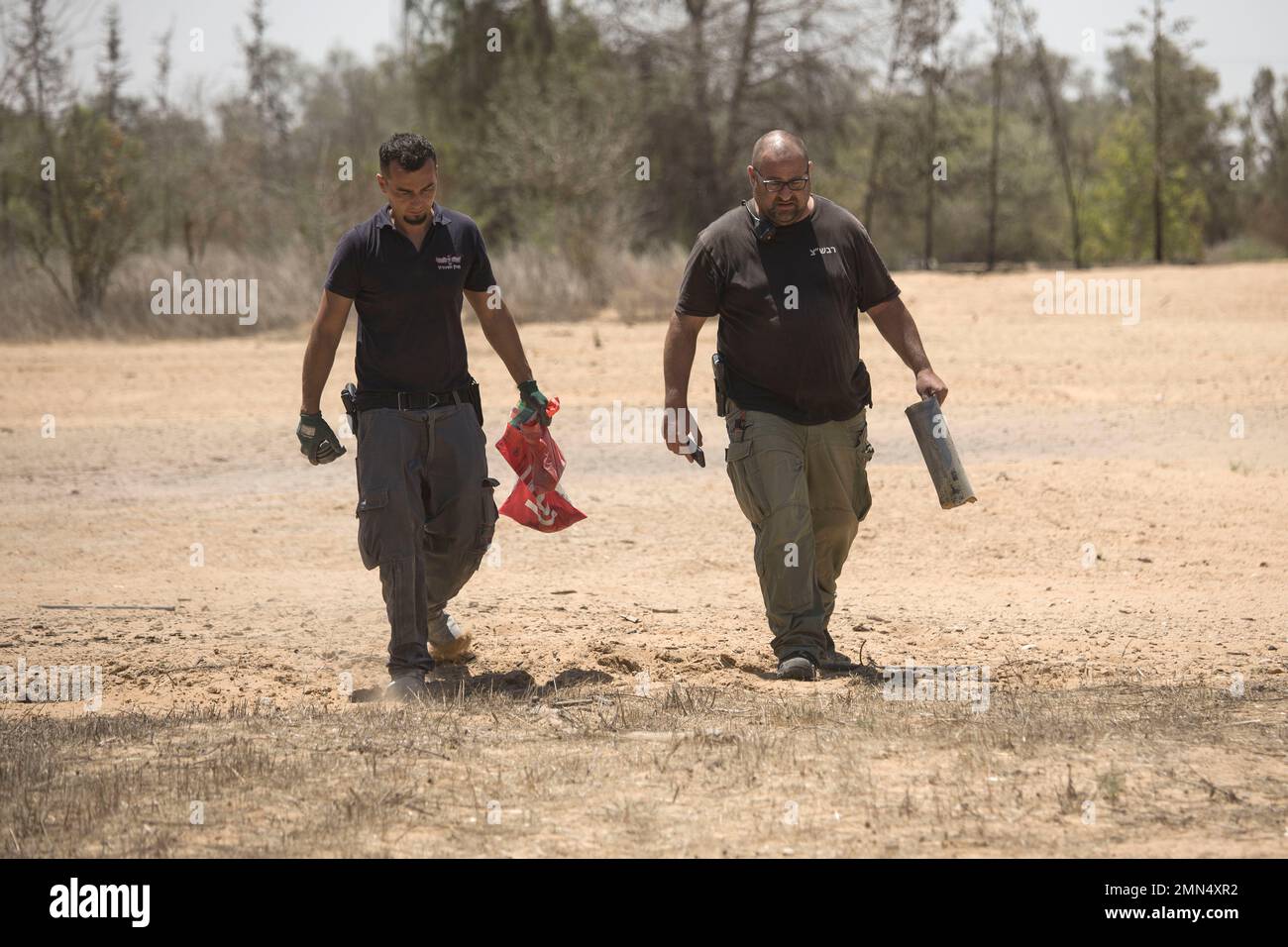Israeli police sapper and a security guard remove a missile launched ...