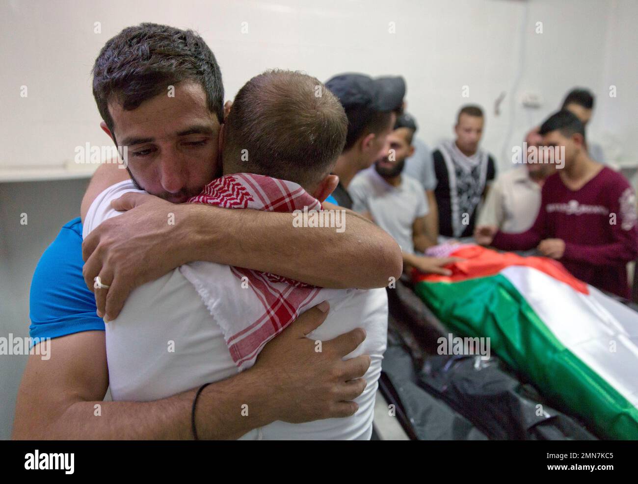 Palestinian mourners comfort each other and bid farewell to Izzideen ...