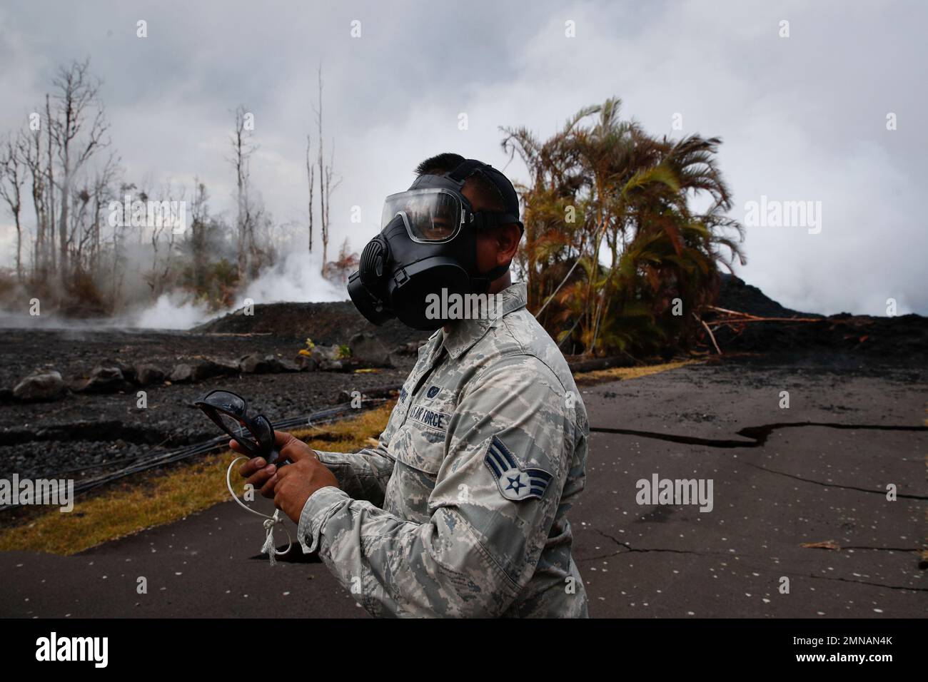 Wearing a gas mask, U.S. Air National Guardsman Orlando Corpuz uses an ...