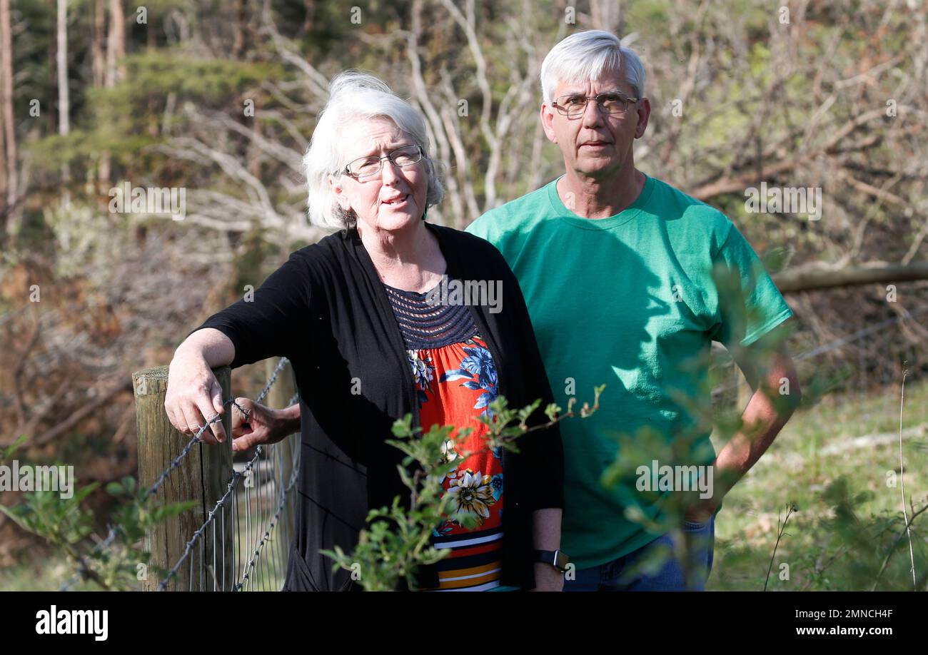 Becky and Roger Crabtree pose next to downed trees on the route of the ...