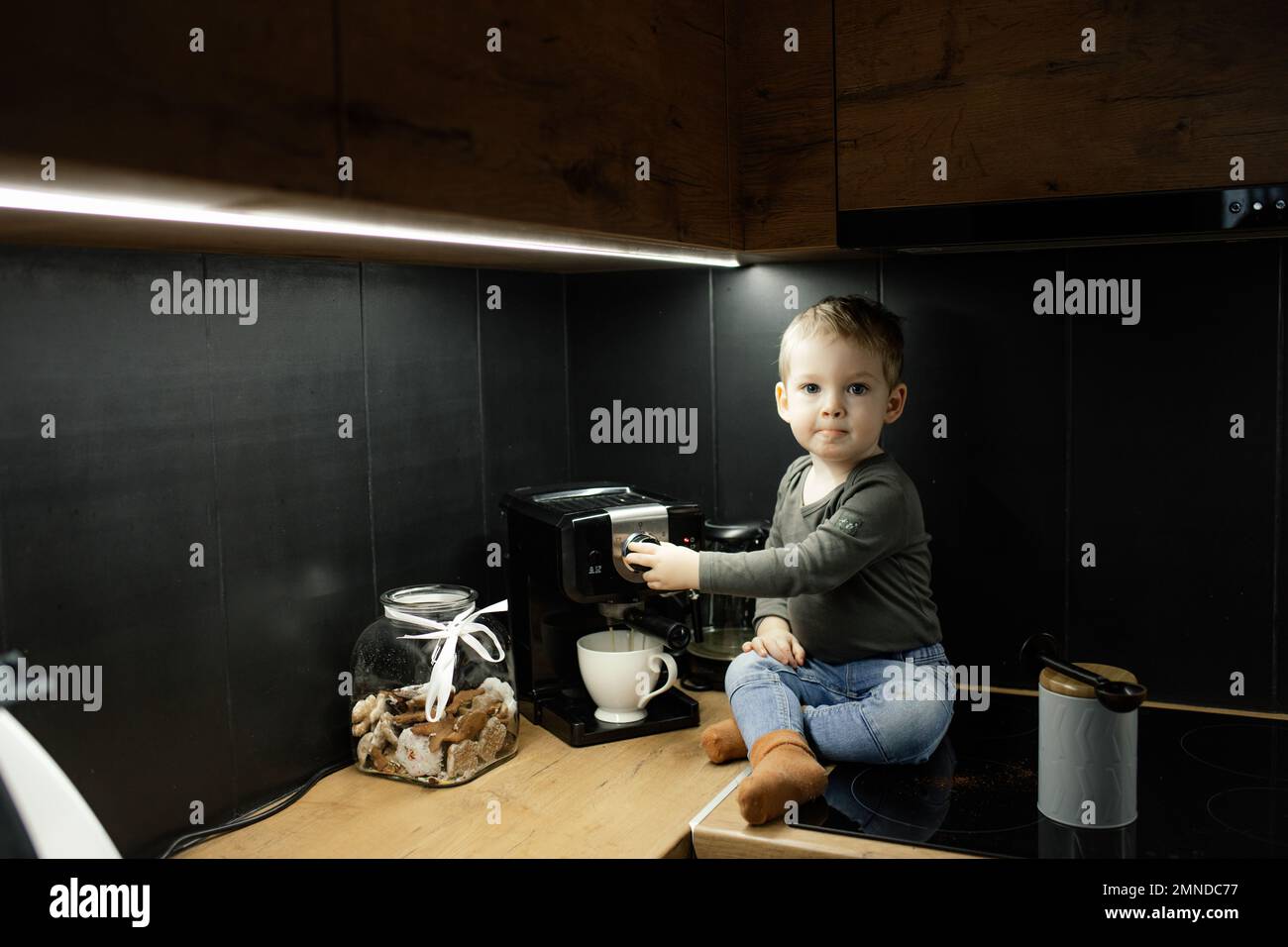 Portrait du petit enfant qui aide à préparer du café. Bébé garçon assis ...