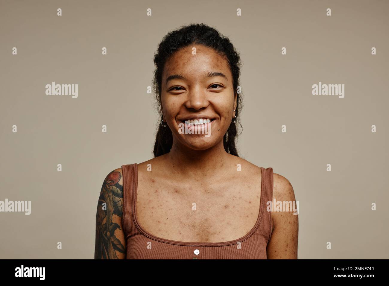 Portrait minimal de jeune femme noire souriant à l'appareil photo ...