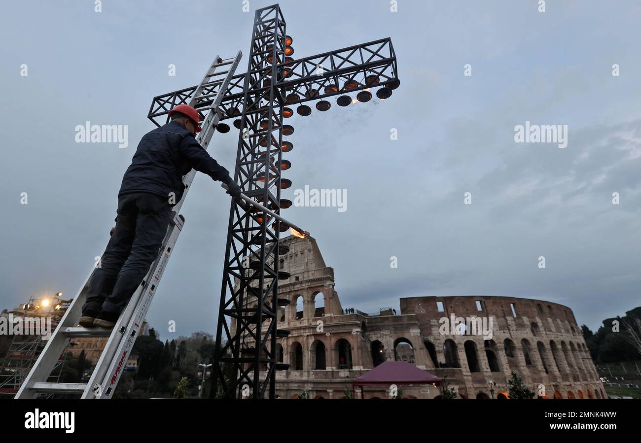 A worker lights the cross ahead of Pope Francis arrival for the Via ...