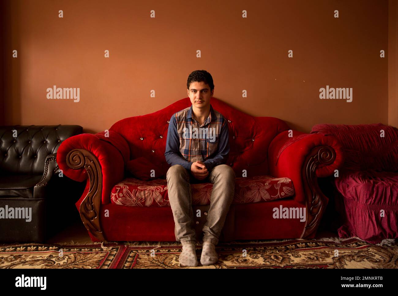 Syrian teenager Hasib Rifat Moustafa poses for a photo in the apartment he shares with his ...