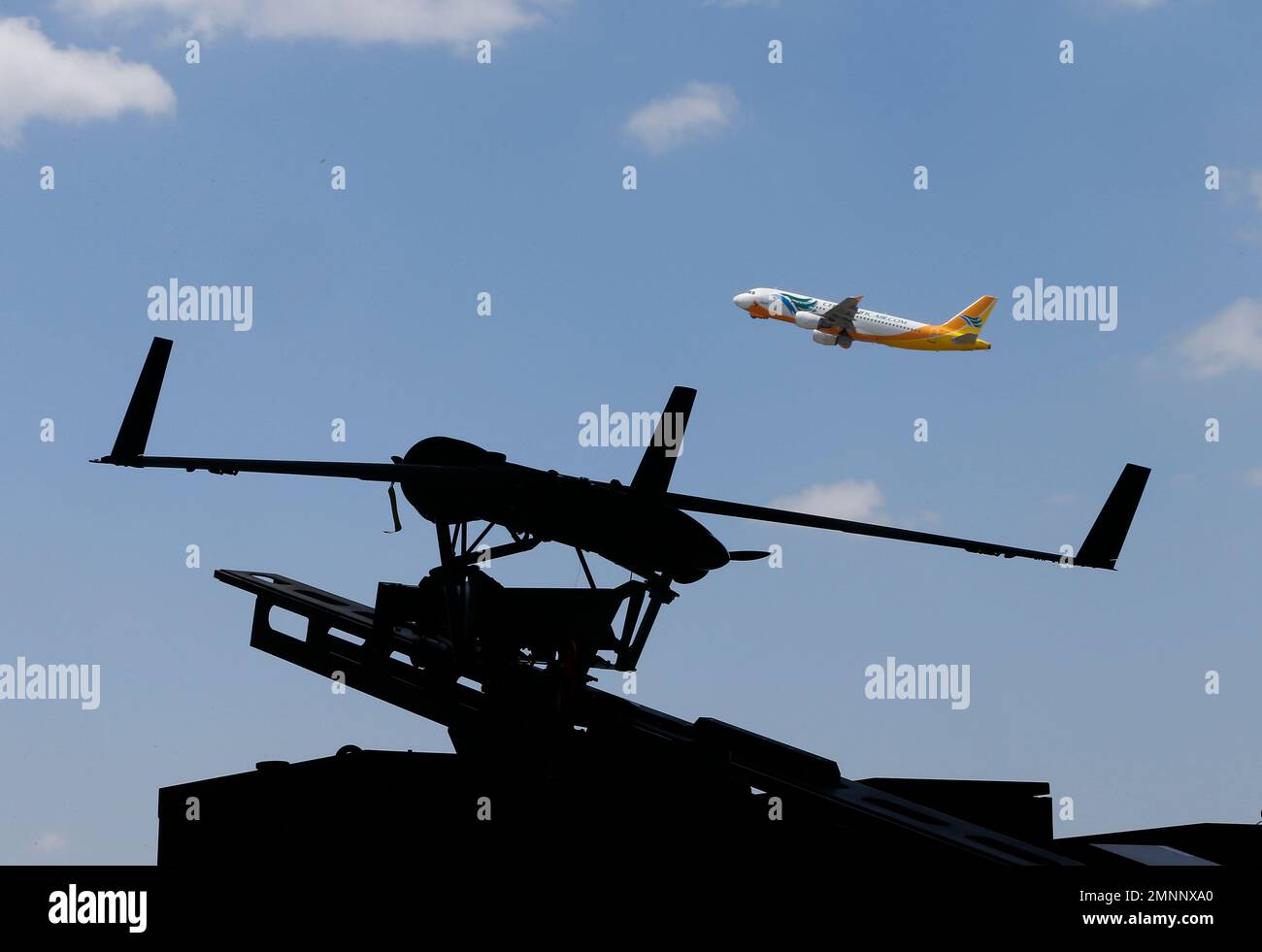 A Cebu Pacific passenger plane takes off as a ScanEagle Unmanned Aerial ...