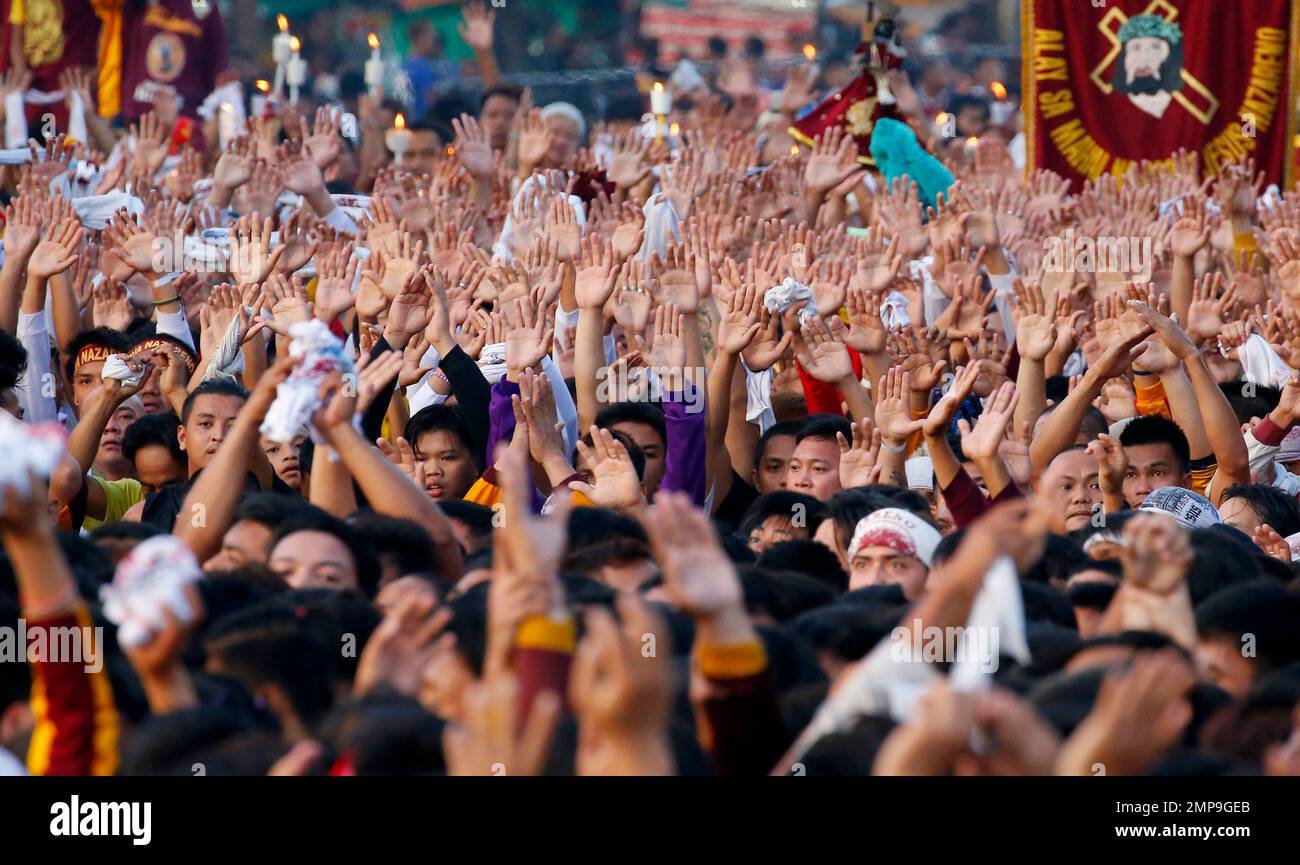 Filipino Roman Catholic devotees raise their hands in prayer during a ...