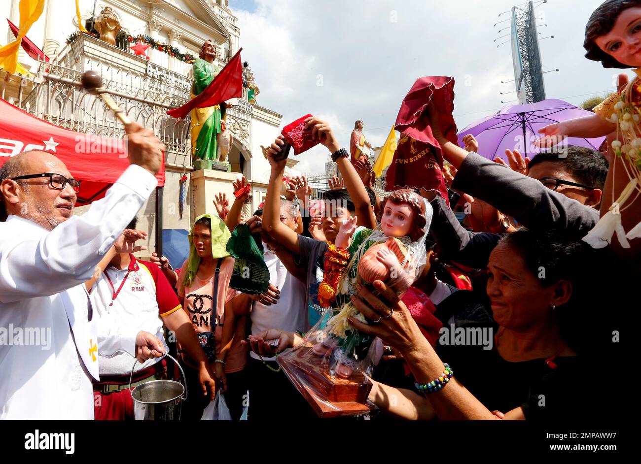 A lay minister blesses with holy water Filipino Roman Catholic devotees ...