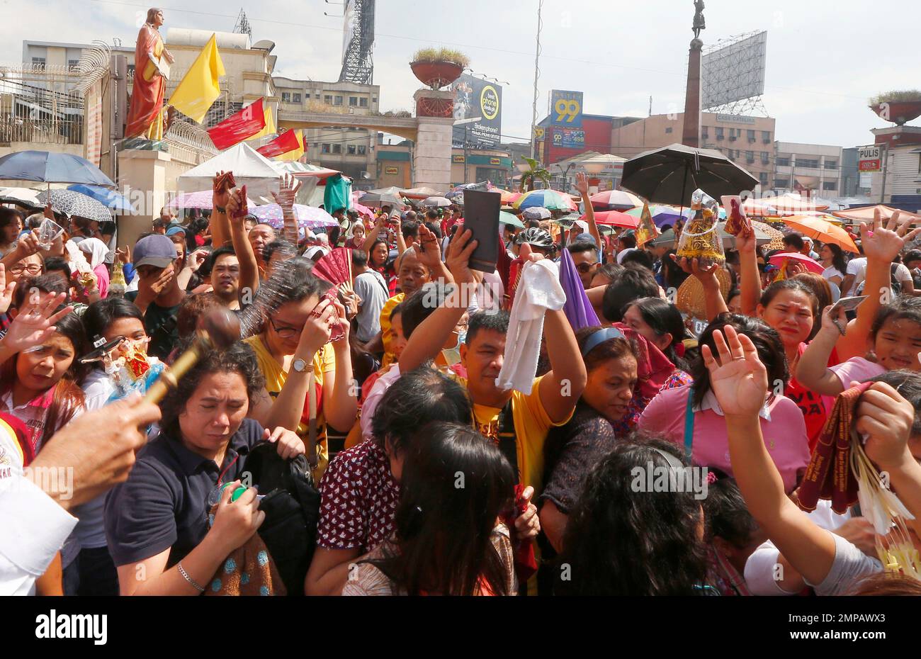 A lay minister blesses with holy water Filipino Roman Catholic devotees ...