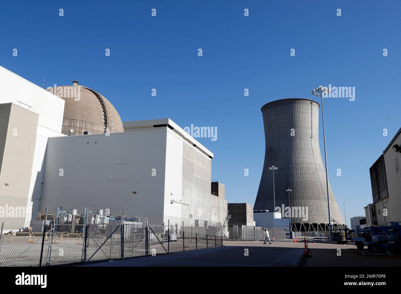 The reactor containment building at left and cooling tower at right are ...