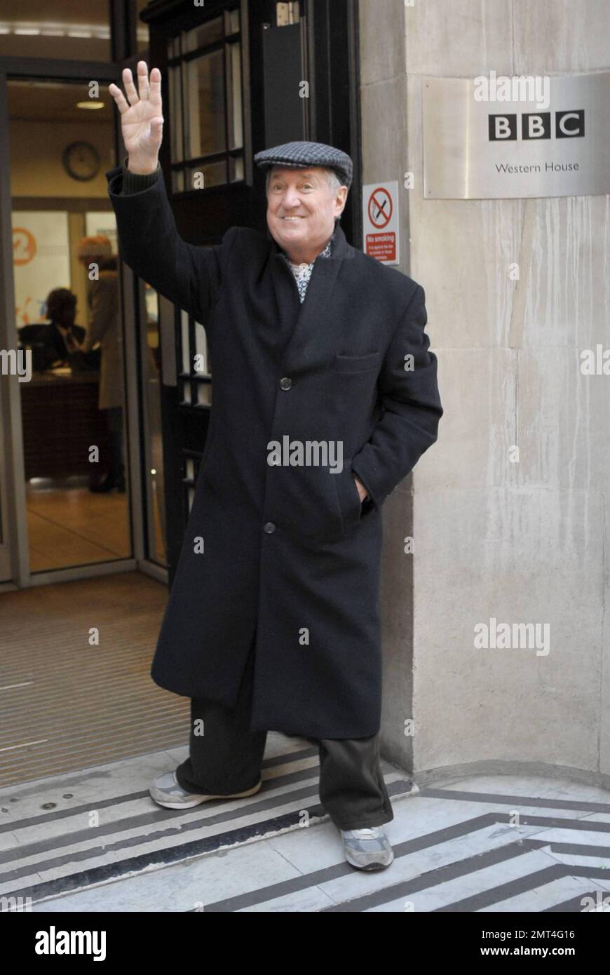 Le chanteur Neil Sedaka fait la vague aux fans et aux photographes lorsqu'il arrive aux studios ...