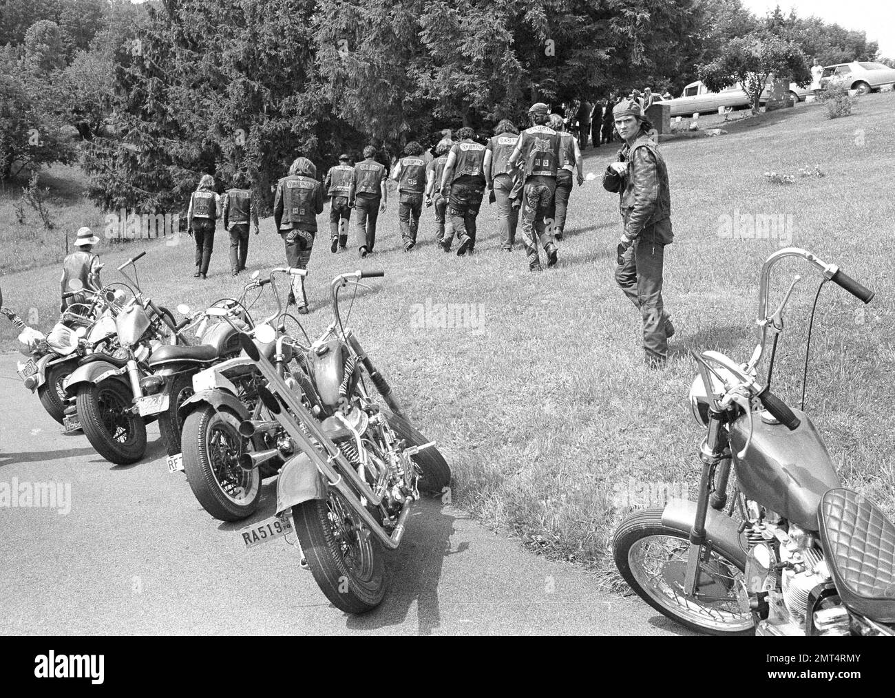 Members of the Pagans motorcycle gang wait for a priest to conclude ...